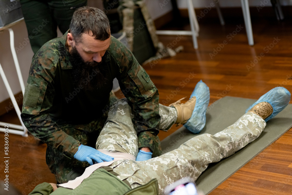 A 40-year-old bearded military medic demonstrates how to pack a wound ...