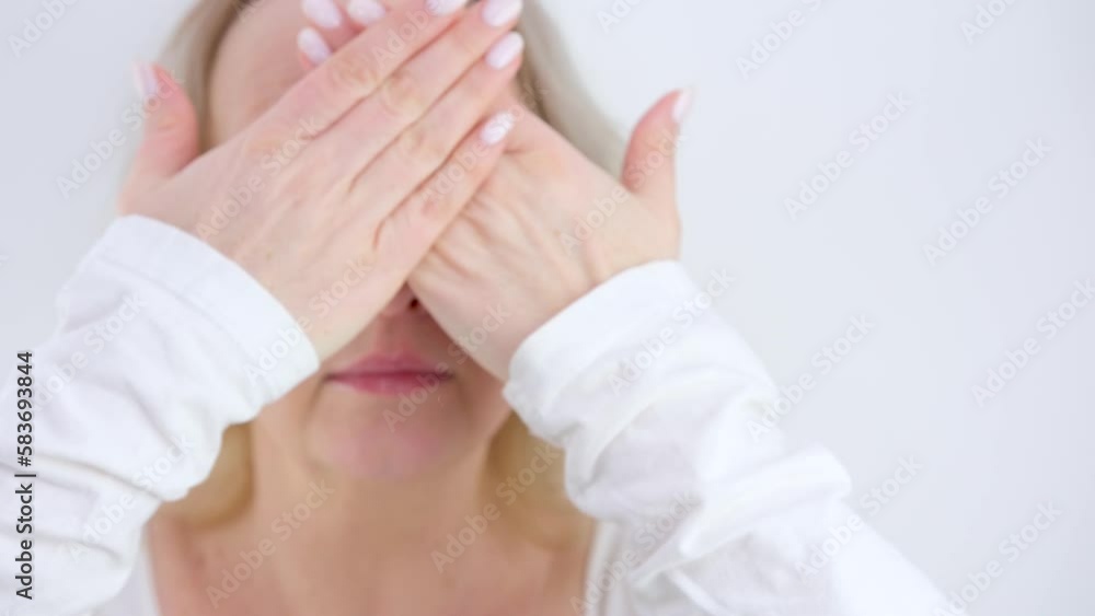 woman closes eyes with both hands put palms on eyes do not want to see ...