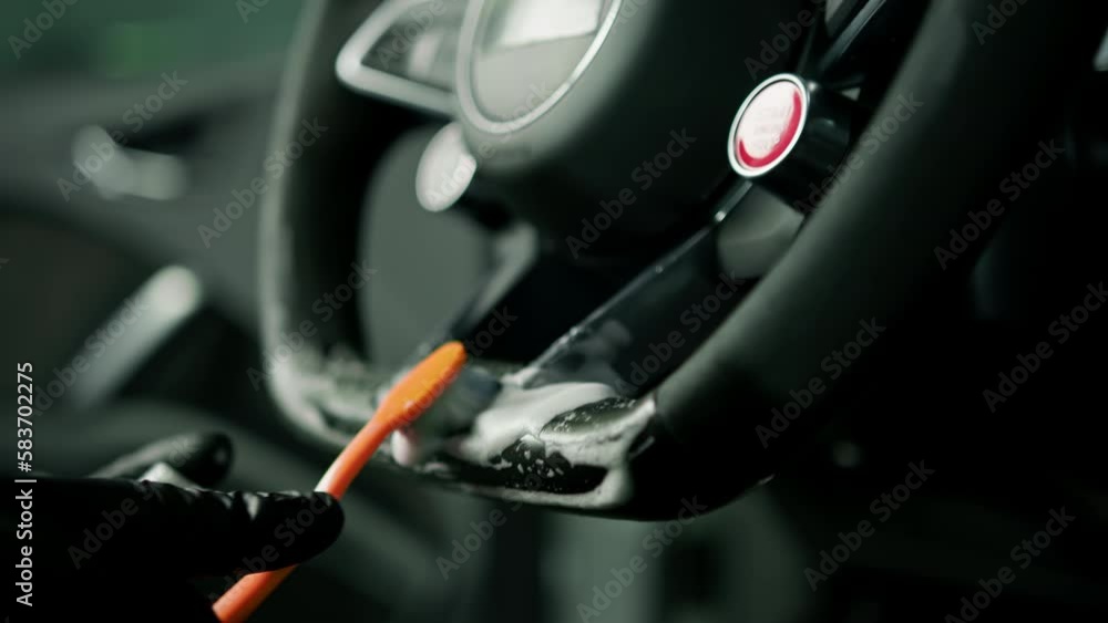 Worker cleans steering wheel professional brush and clout of microfiber ...