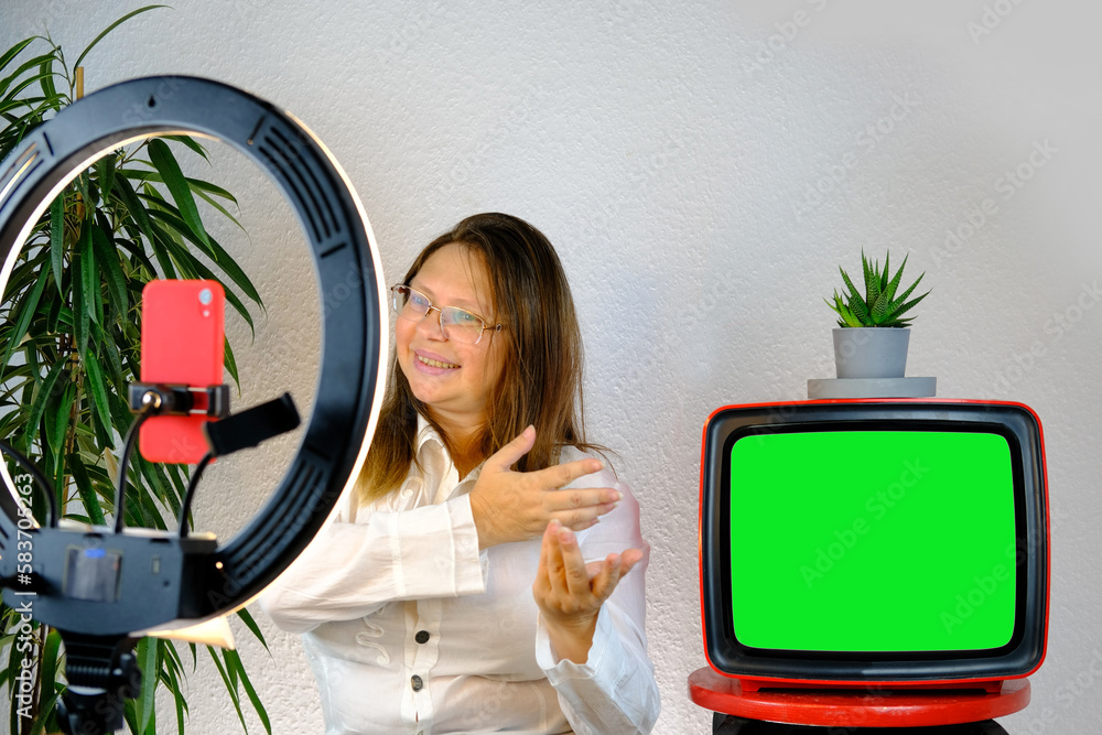 woman 40-45 years old, pretty female blogger sits in front of ring ...