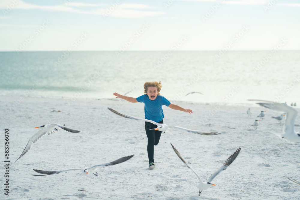 Stockfoto Carefree child. Kid runs along the coast and chases the birds ...