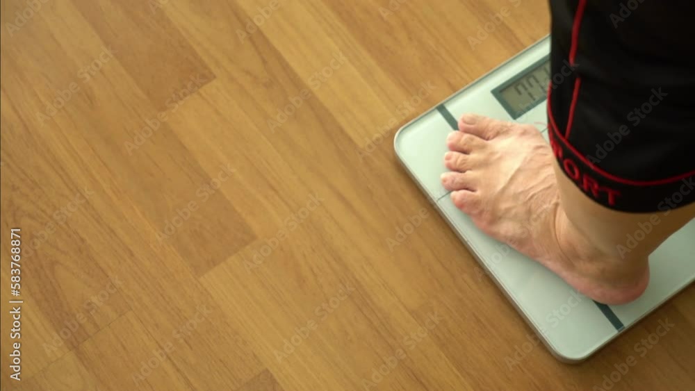 man stepping onto a scale to check her weight. men bare foot legs ...