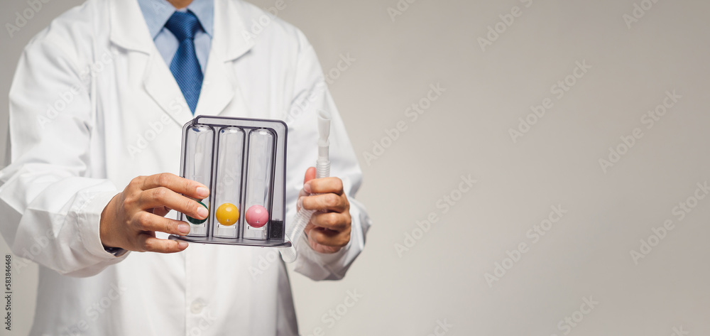 Doctor holding an incentive spirometer to help perform deep breathing ...
