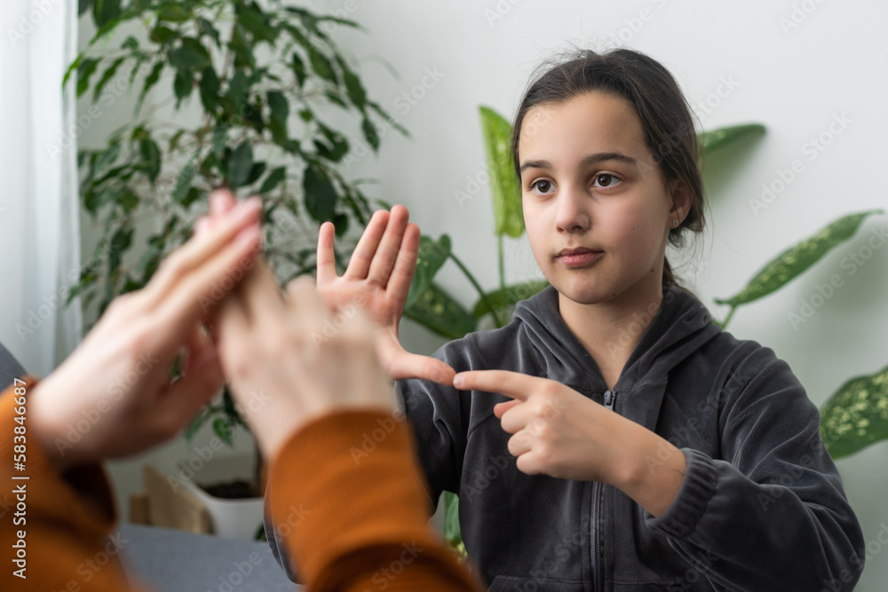 Cute little girl make hand gesture learning sign language with mom or ...