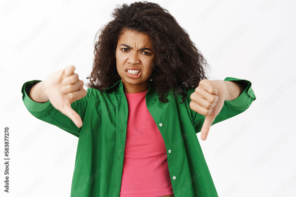 Angry and disappointed Black woman, shows thumbs down, dislike and ...