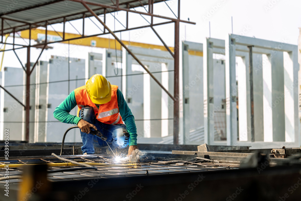 Workers at a construction site weld metal structures of precast ...