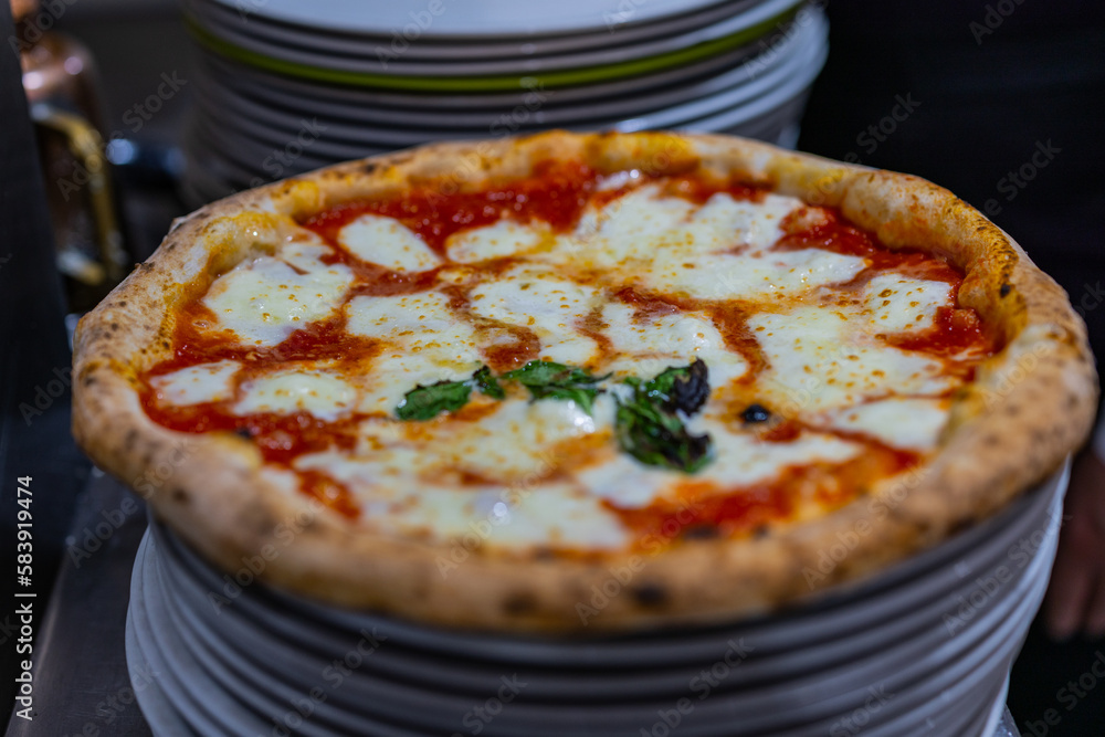 Pizza Margherita tradizionale napoletana a ruota di carro condita con ...