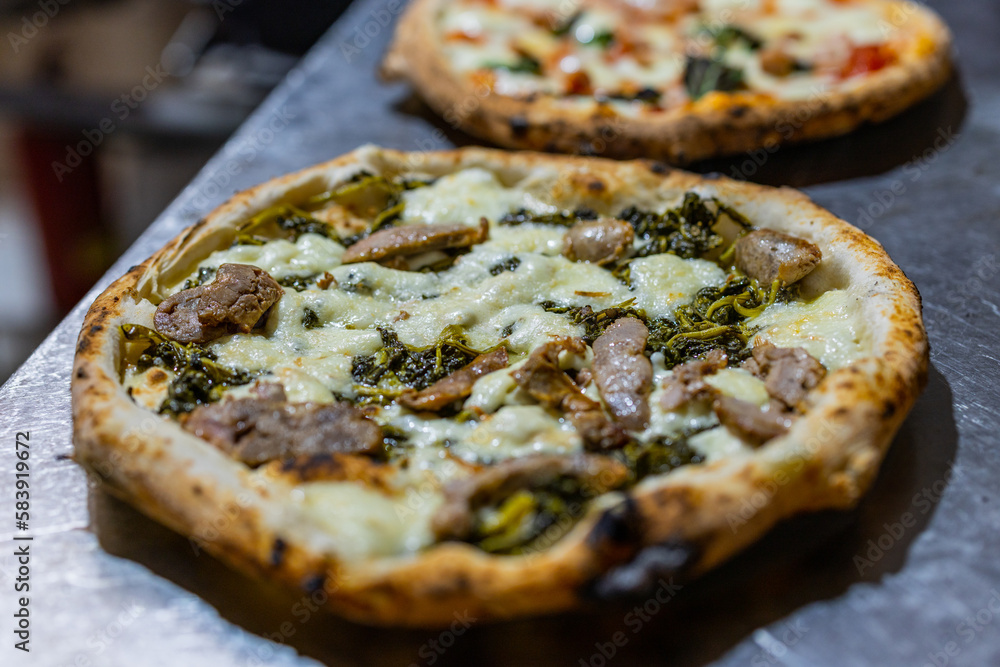 Pizza tradizionale napoletana a ruota di carro condita con salsiccia ...