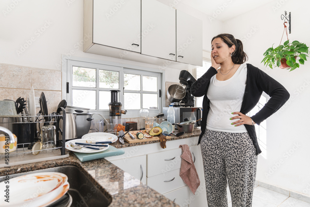 Hispanic woman stressed out because of the mess and dirt in the kitchen ...