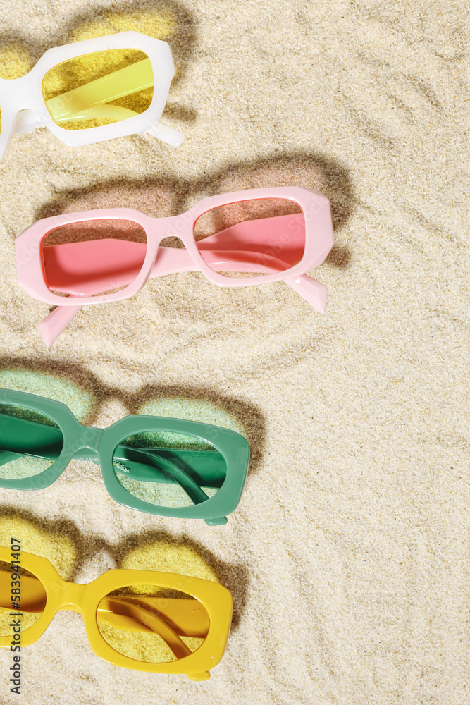 Set of colorful sunglasses on beach sand background at sunlight with ...