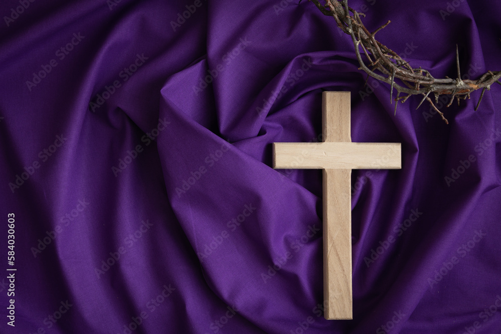 Wood Christian cross and partial crown of thorns on a dark purple ...