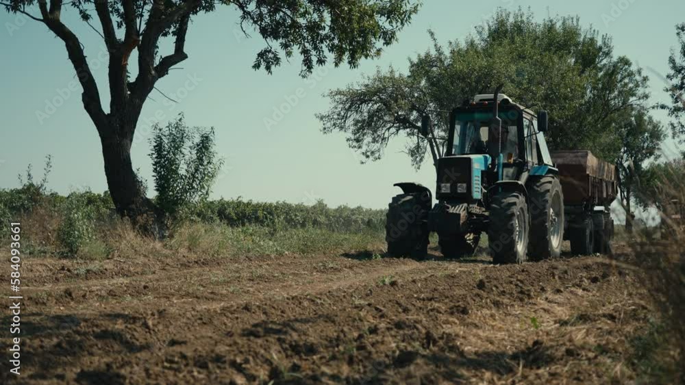 Tractor equipment driving on the dirty road at the agricultural farm ...