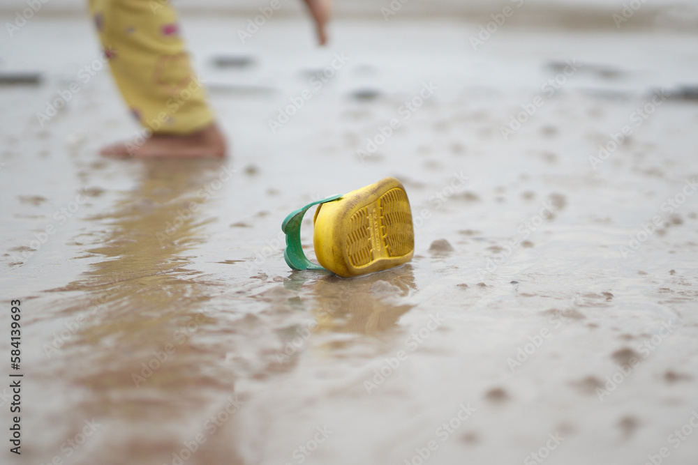 child drowned on the beach. A photo of a yellow sandal on the beach ...