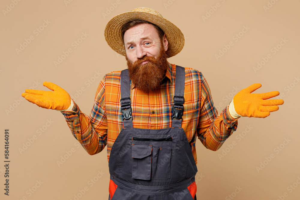Sad young dissatisfied bearded man wear straw hat overalls work in ...