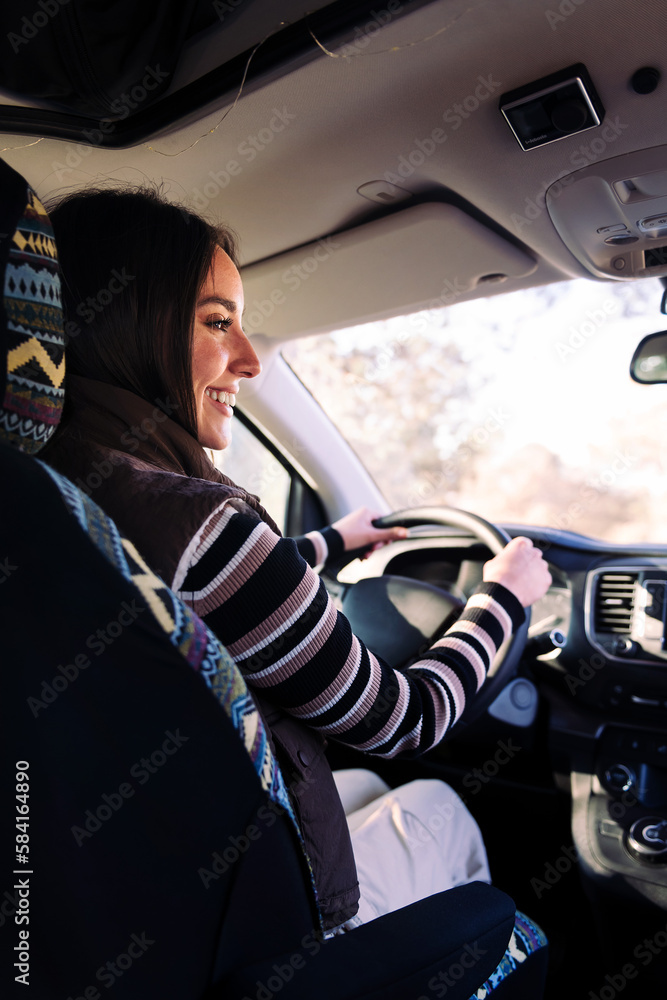 smiling young caucasian woman driving her camper van to new horizons ...