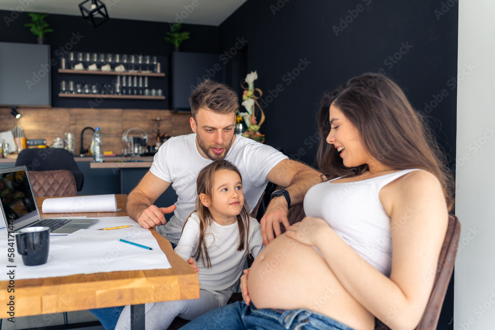 A young family is sitting at a writing table, dad and daughter are ...