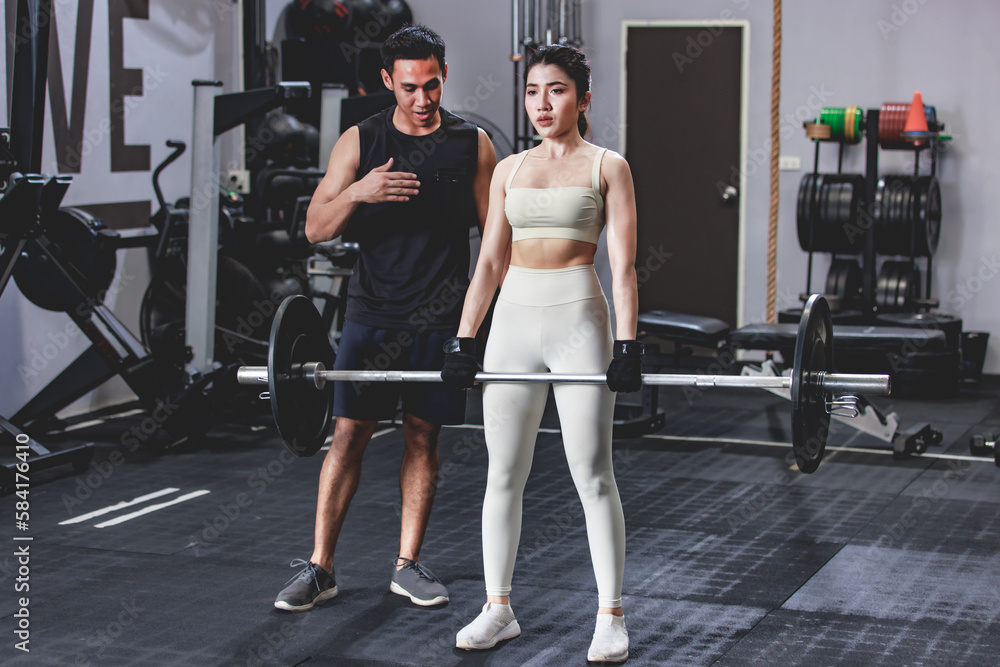 Asian professional male personal trainer coaching young muscular fit ...