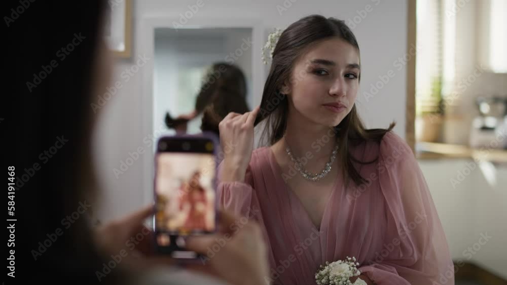Mother taking picture of her daughter in dress before prom party. Shot ...