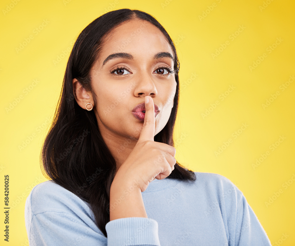 Secret, portrait and woman with finger on lips in studio, yellow ...