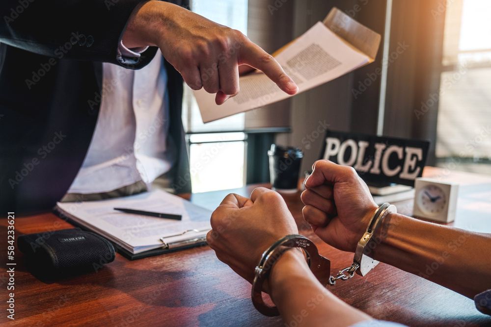 Law enforcement officer interrogating Criminals male with handcuffs in ...