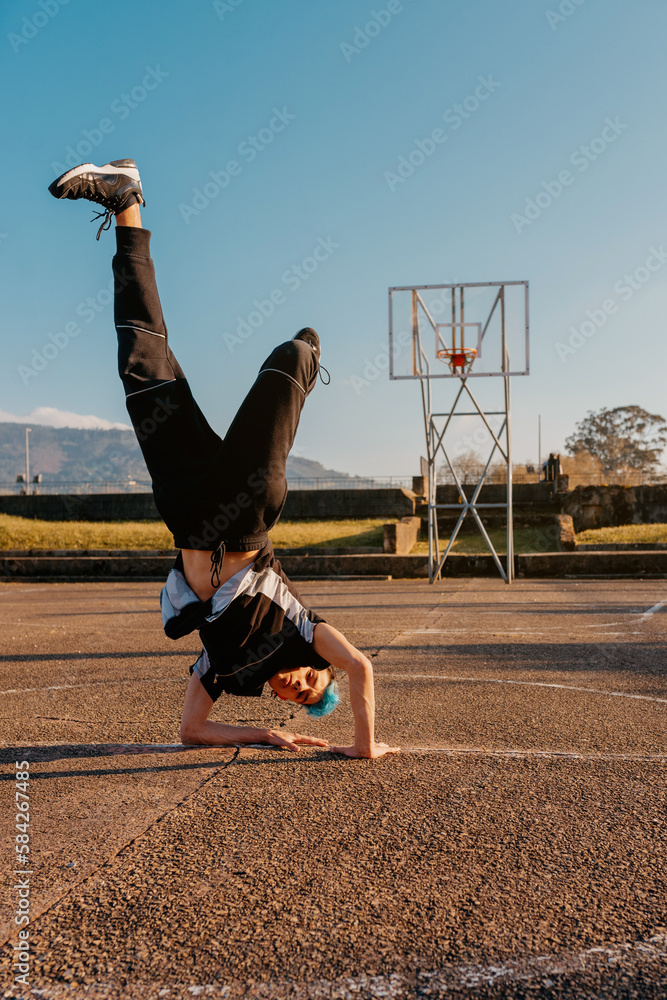 caucasian teenage boy doing the pino on a basketball court. young boy ...