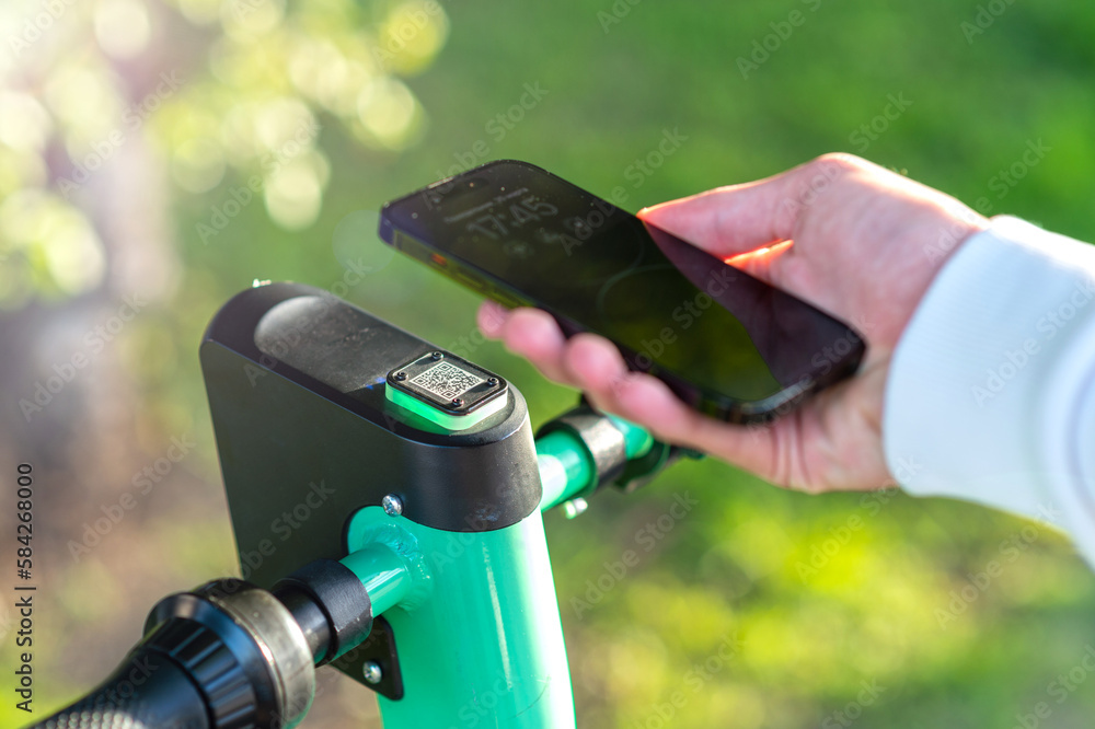 Scanning electric scooter QR-code by phone. Pointing a mobile-phone ...