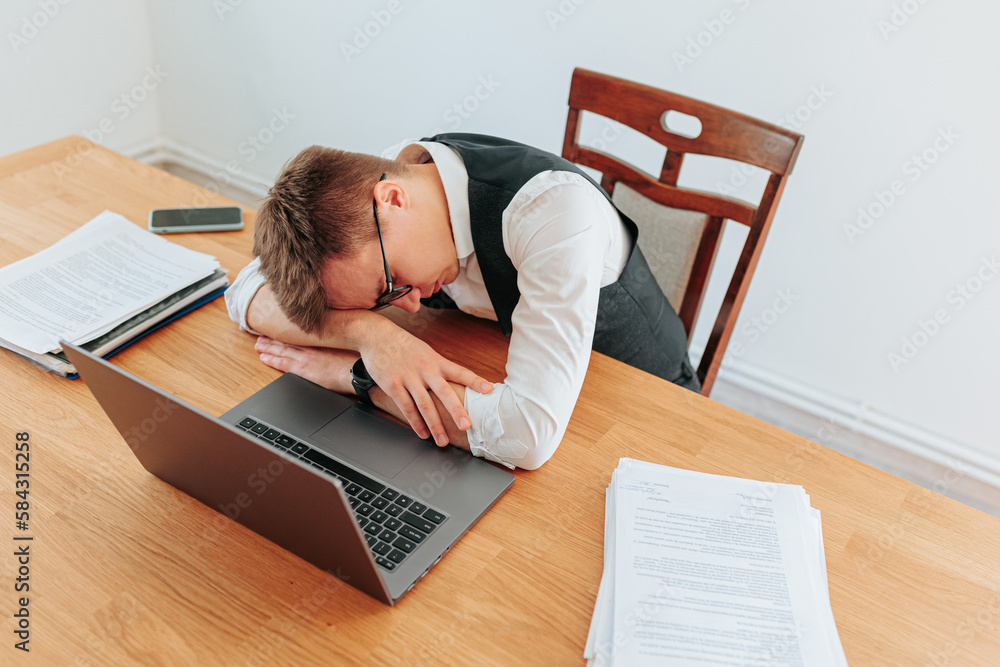 A worker takes a moment to close his eyes and rest, seeking relief from ...