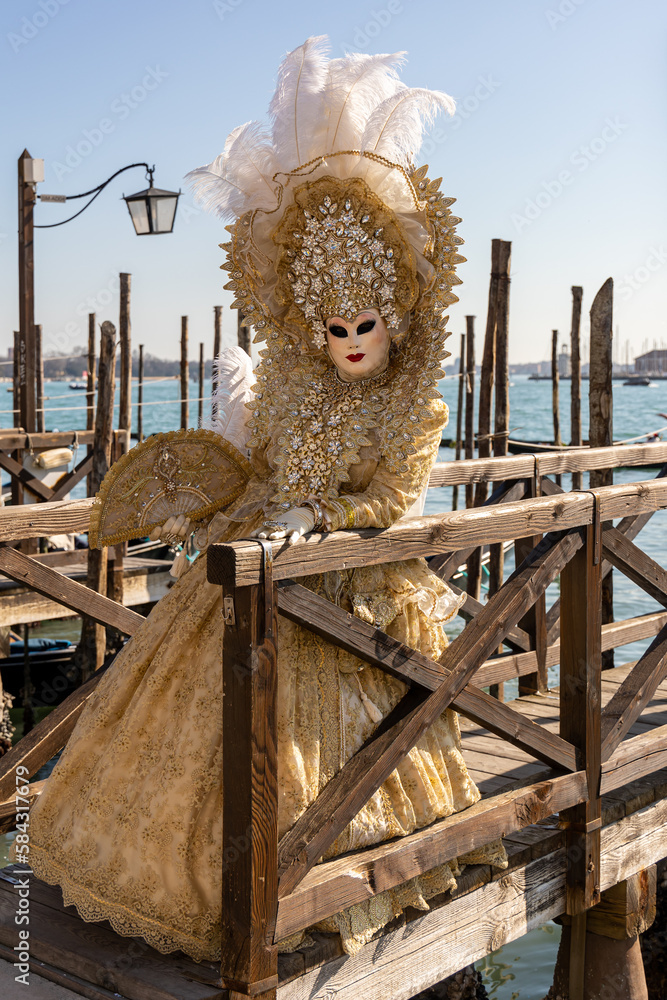 Venice carnival 2023, an unrecognizable masked model posed near a canal ...