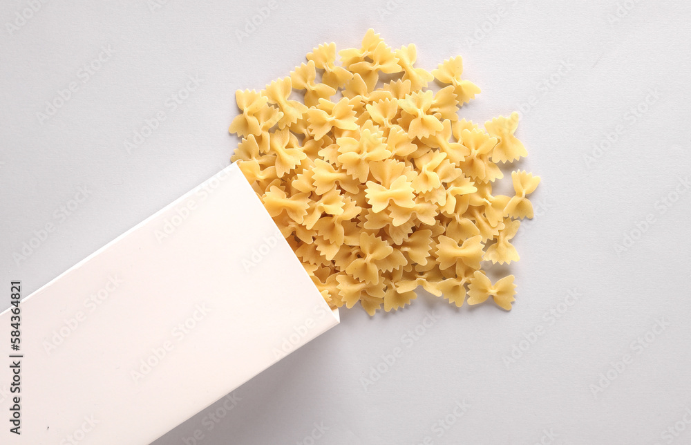 Mockup of a white box with scattered pasta bows on a gray background ...