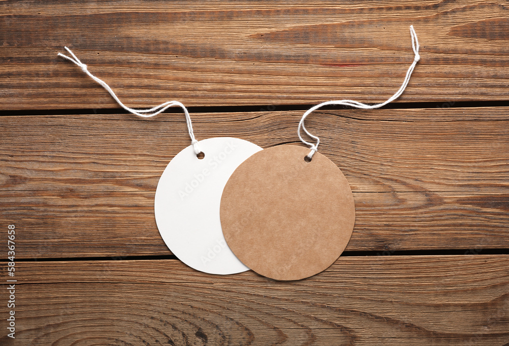 Empty round craft and white paper price tags with string on wooden ...