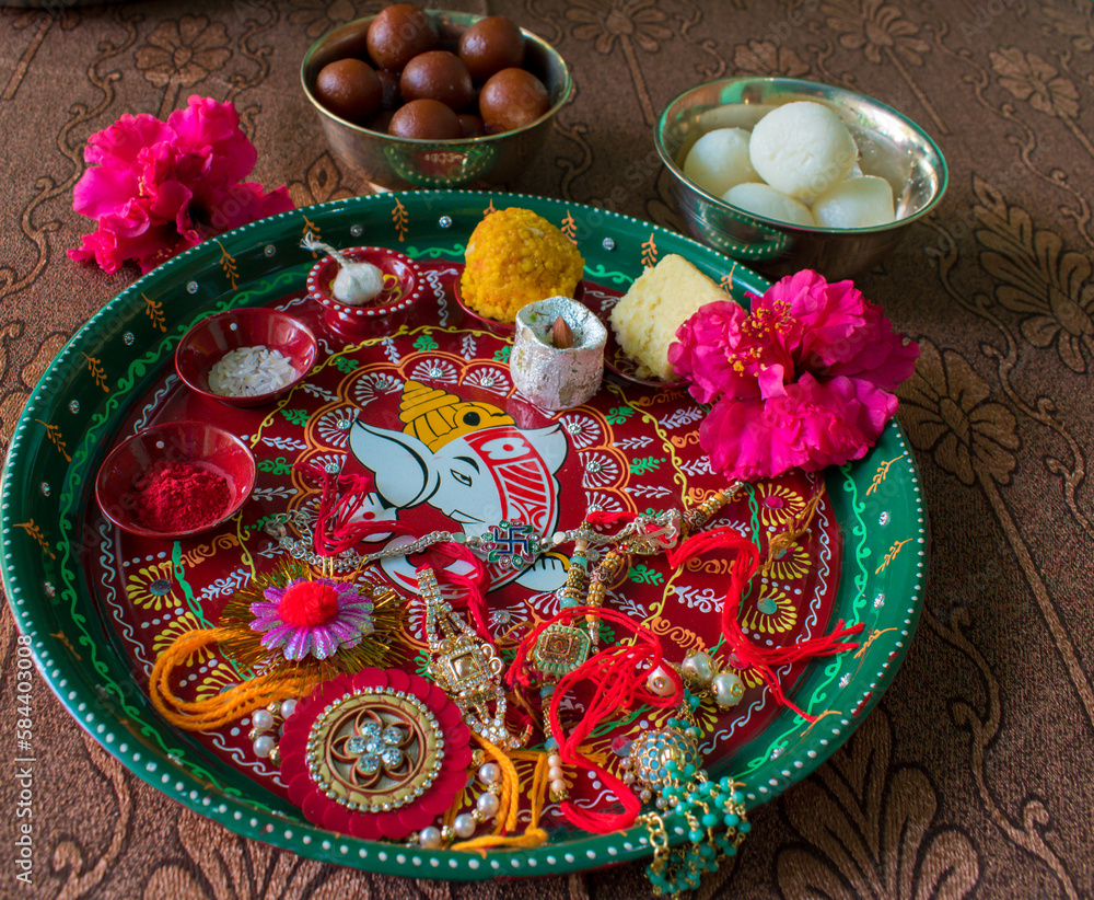 Decorated pooja plate or thali containing rice grain, kumkum, ladoo ...