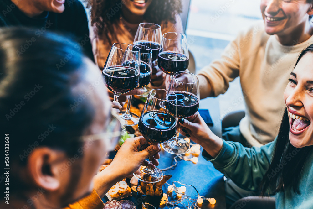 Happy group of friends toasting and drinking red wine together at bar ...