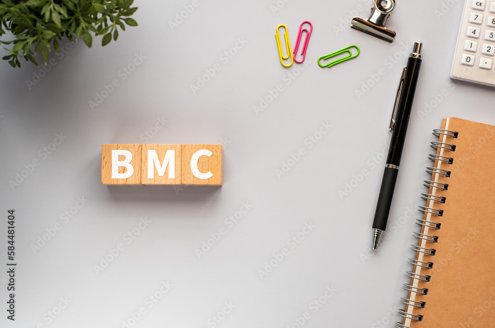 There is wood cube with the word BMC.It is an abbreviation for Business Model Canvas as eye ...