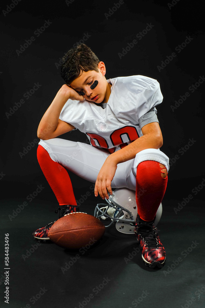 Youth preteen boy football player sitting on helmet in studio Stock ...