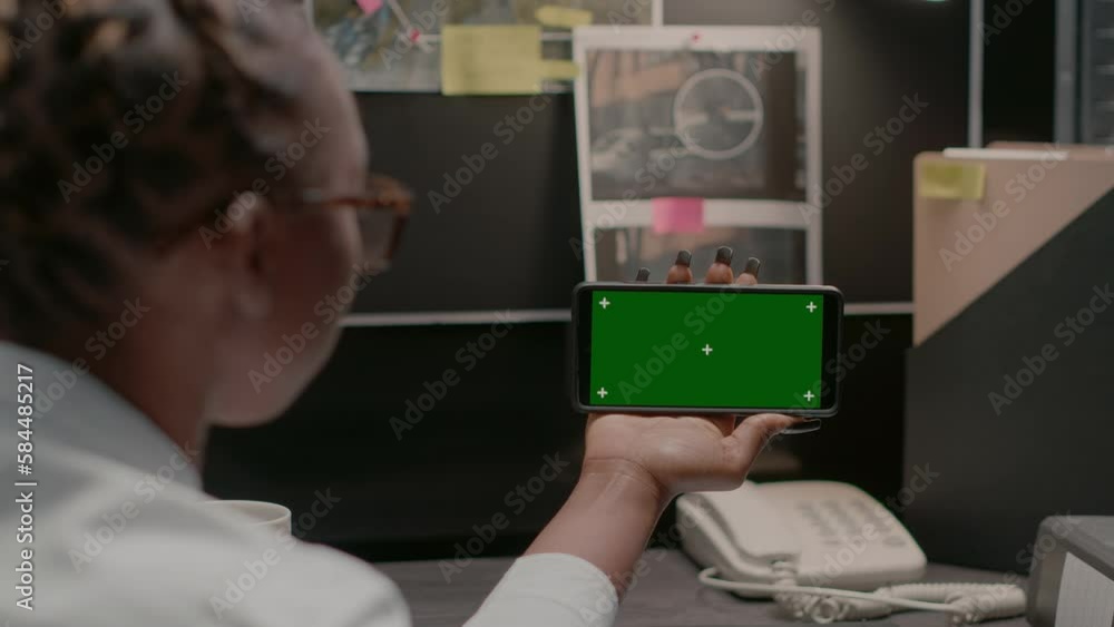 Police officer using greenscreen in evidence room, showing mockup ...