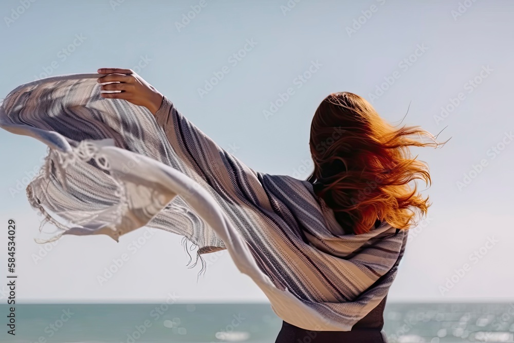 Scarf flying in the wind. Woman with long hair enjoying the beach with ...