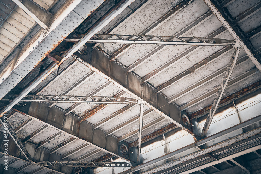 Bottom up view of beams, girders and bolts of metal bridge. Riveted ...