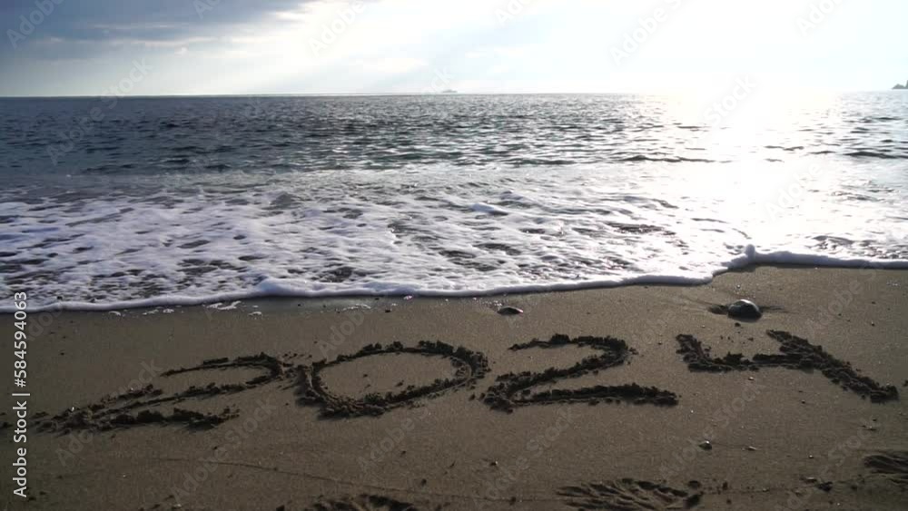 Happy new year 2024. number 2024 hand written in the golden sand on ...