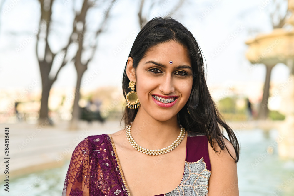 A smiling Indian woman wearing traditional clothing and braces on her ...