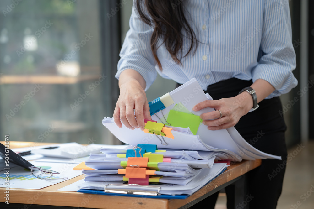 Businesswoman hands working in Stacks of paper files for searching and ...