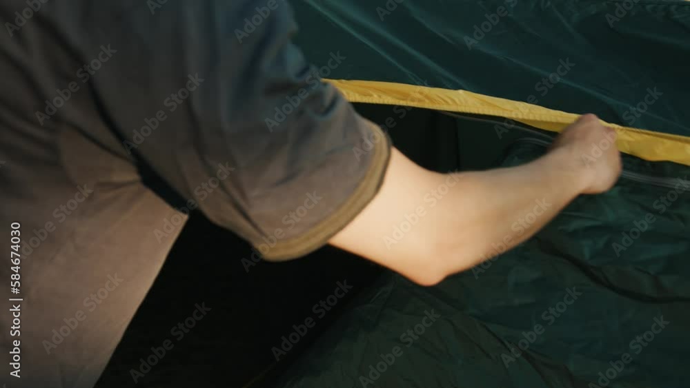 A close-up finger of a man's hands that opens the zipper on the ...