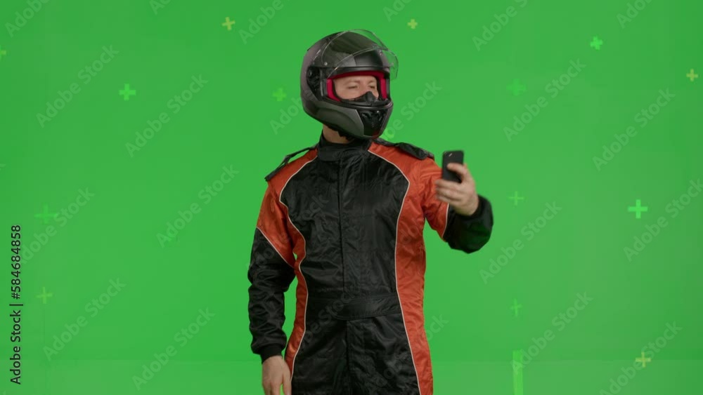 racing driver using smartphone on green screen background, portrait of ...