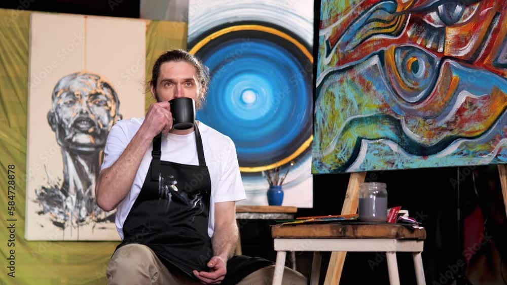 Portrait of handsome artist thinking drinking hot coffee in studio near ...