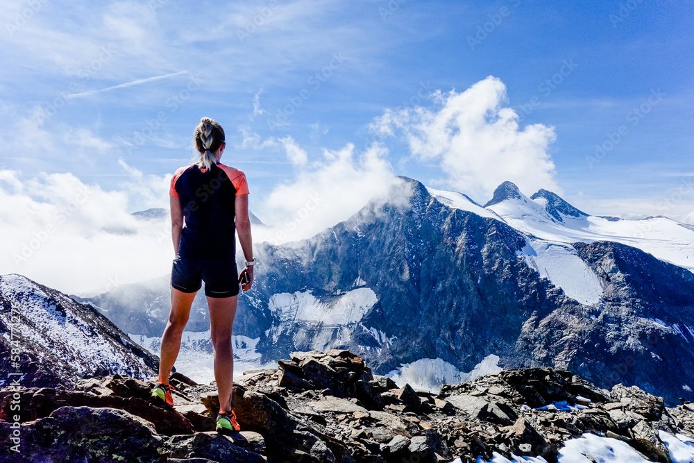 sportliche Frau am Berg am Gletscher bei blauem Himmel und Wolken Stock ...