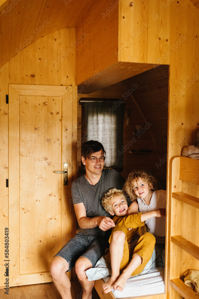 Foto de Father and kids in a tiny house with his kids being sweet do ...