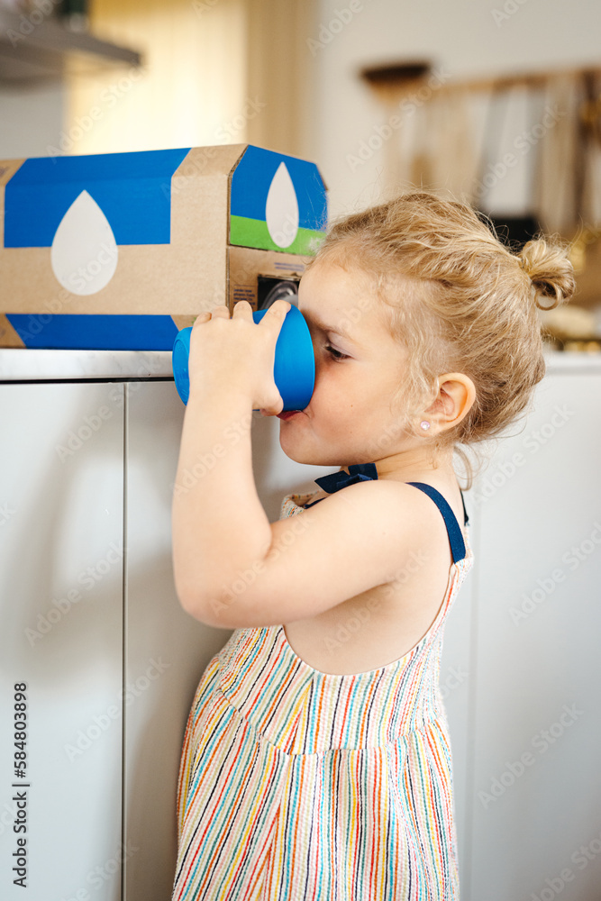 Kid pouring water from a dispenser Stock Photo | Adobe Stock