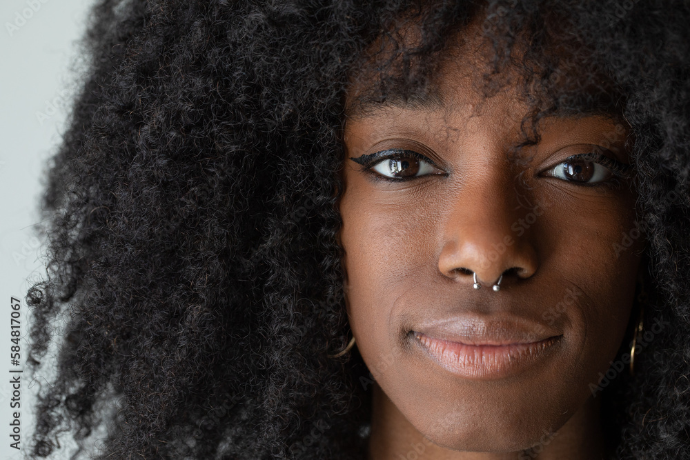 Face of a young African girl with piercing in her nose and afro ...