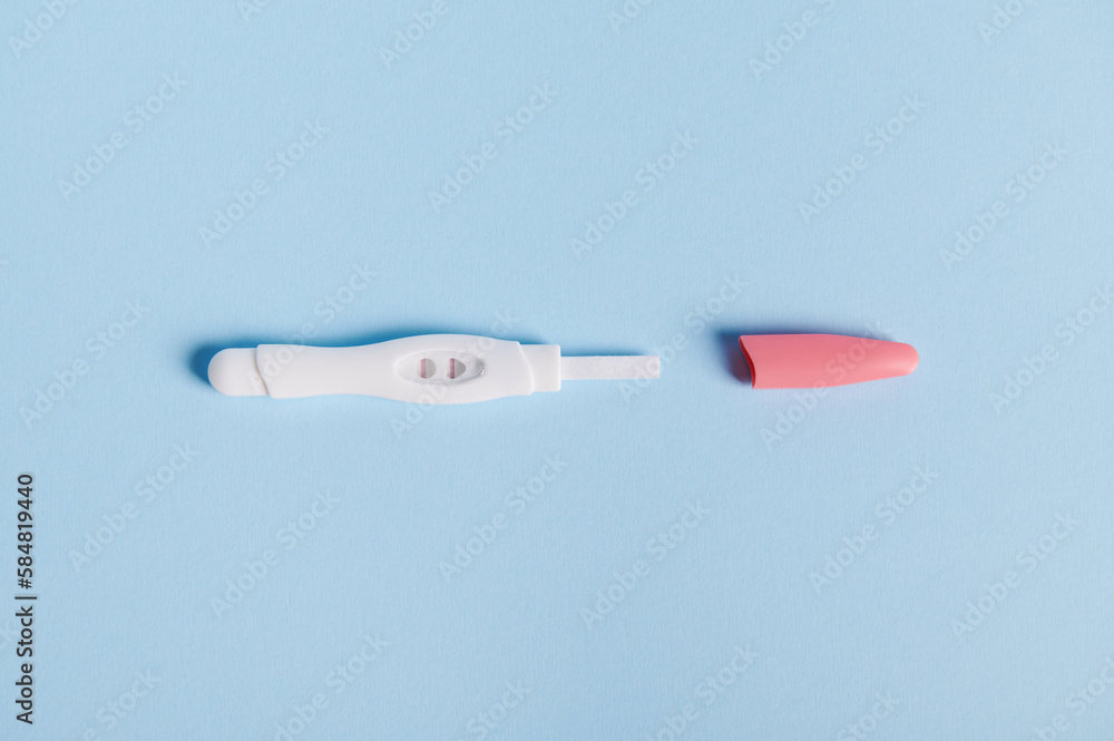 Isolated shot of positive pregnancy test kit with two strips on blue ...