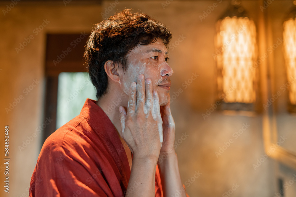 Asian man washing his face with white foaming cleanser Stock Photo | Adobe Stock