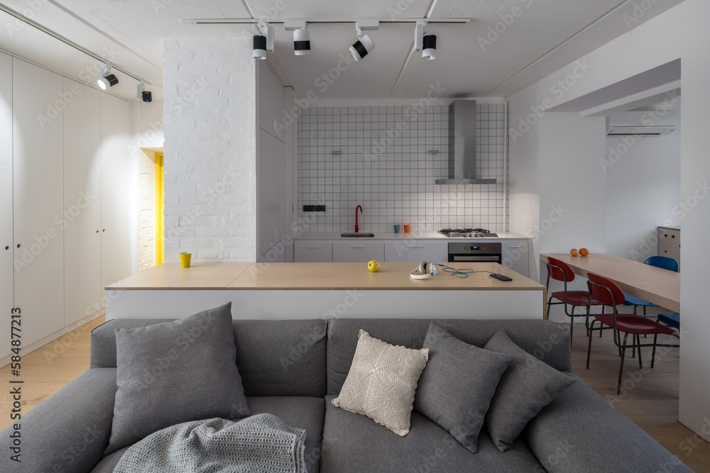 Open plan studio apartment with small white kitchen and living room ...